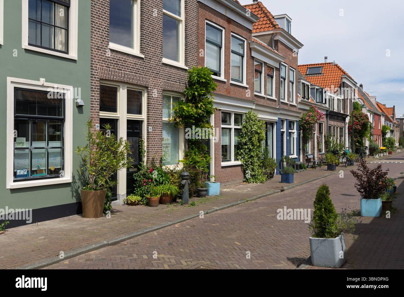 A quaint, brick-paved street in Delft, lined with charming traditional ...
