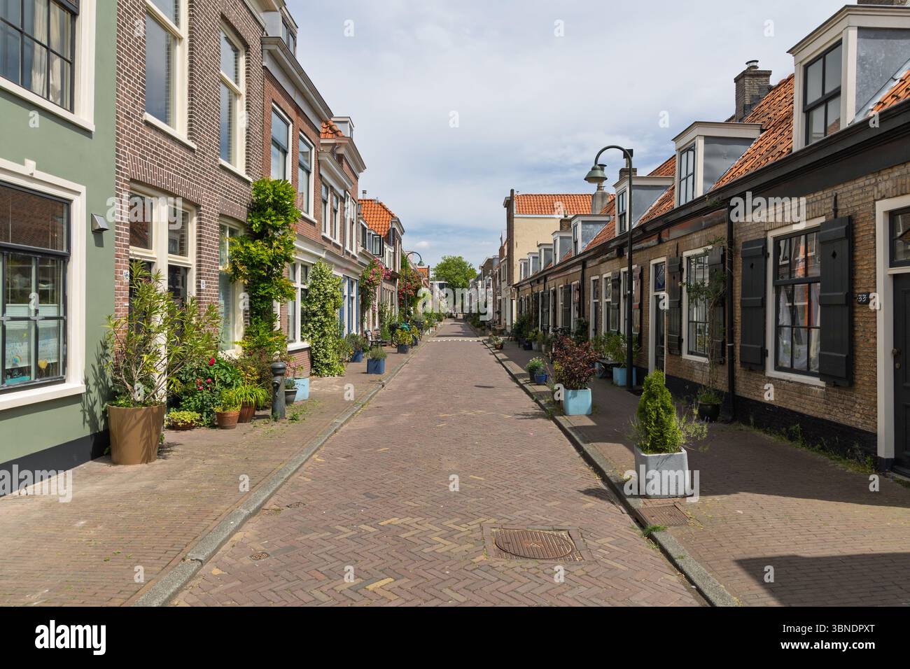 A quaint, brick-paved street in Delft, lined with charming traditional ...