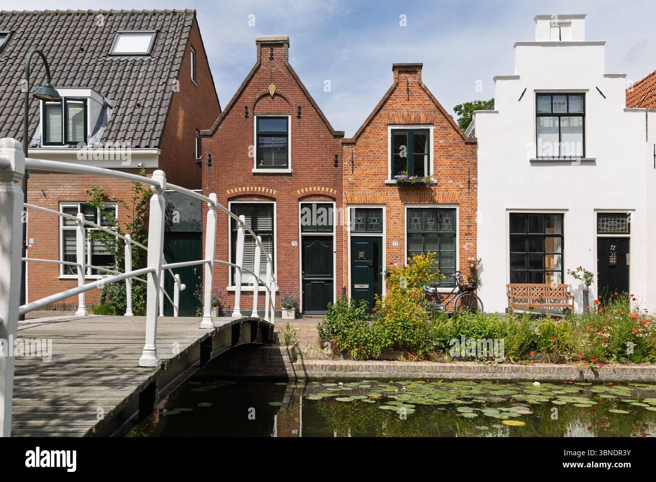 A charming Dutch canal scene in Delft, with traditional gable houses, a ...