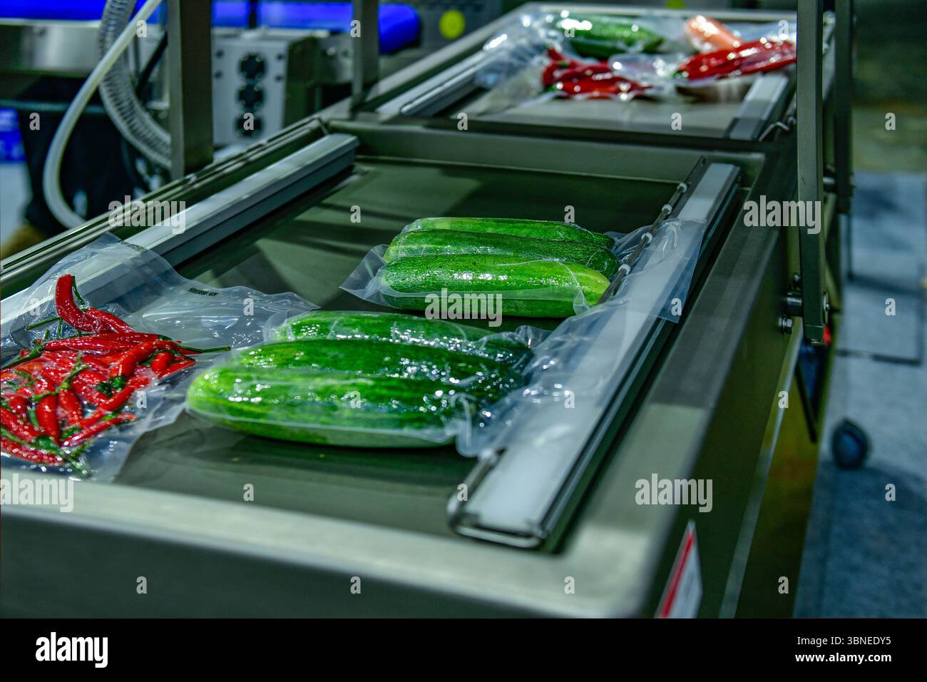 Fresh vegetables packed in a clear plastic wrap production line in ...