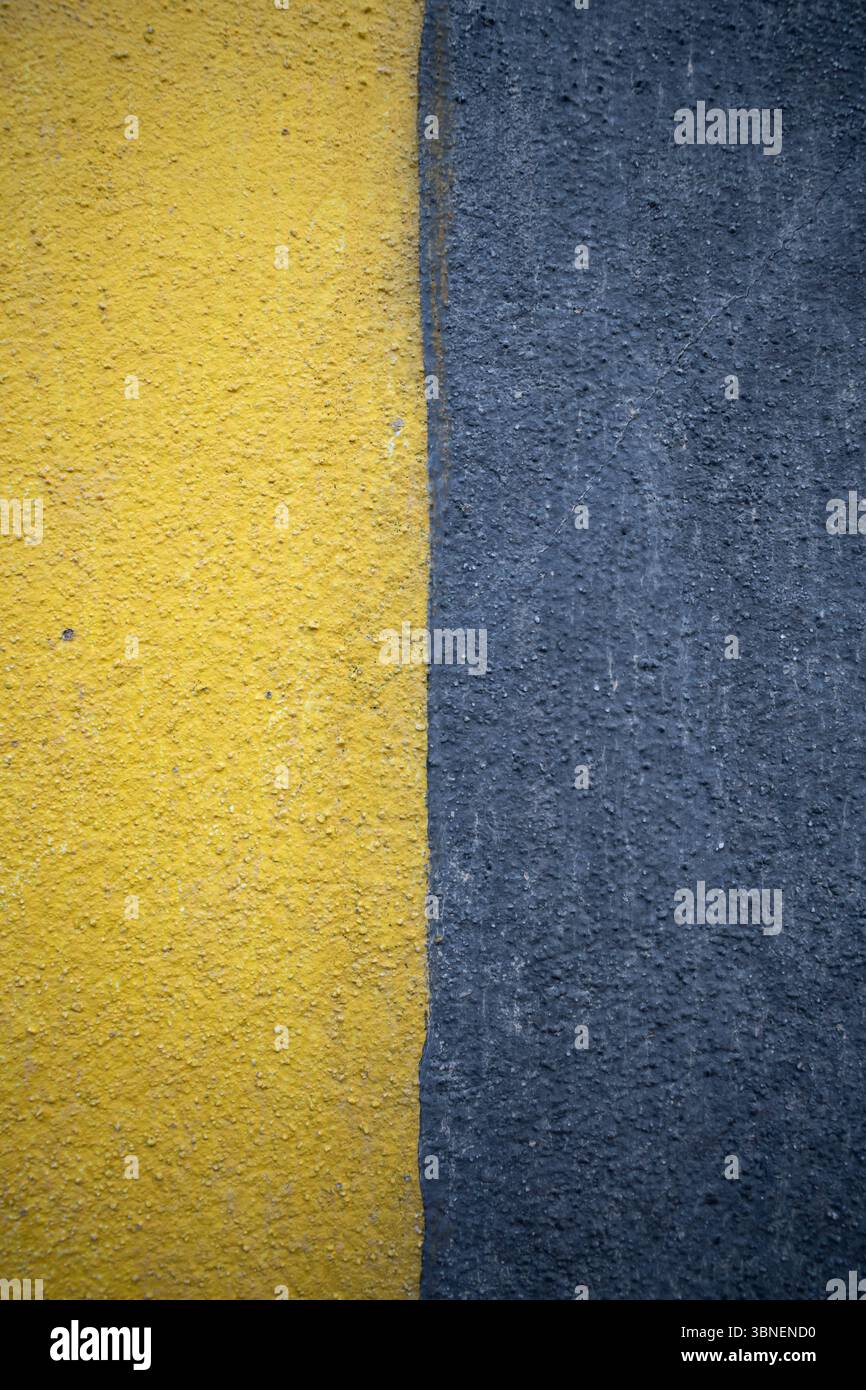Yellow and black background, wall with plaster painted in two parallel ...