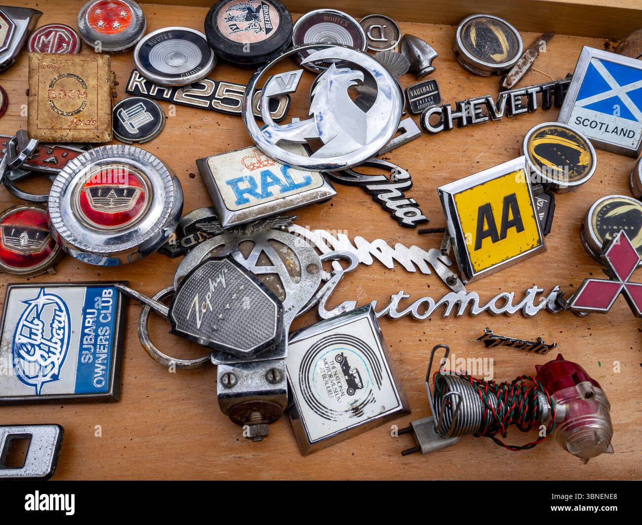 A collection of rescued repurposed classic car badges on a wooden tray ...