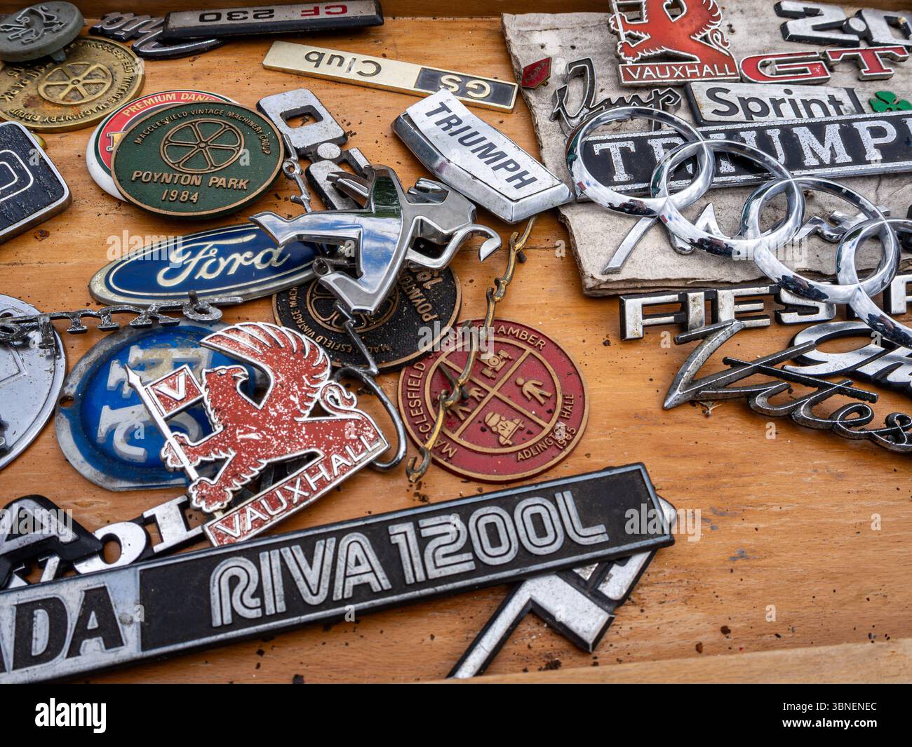 A collection of rescued repurposed classic car badges on a wooden tray ...