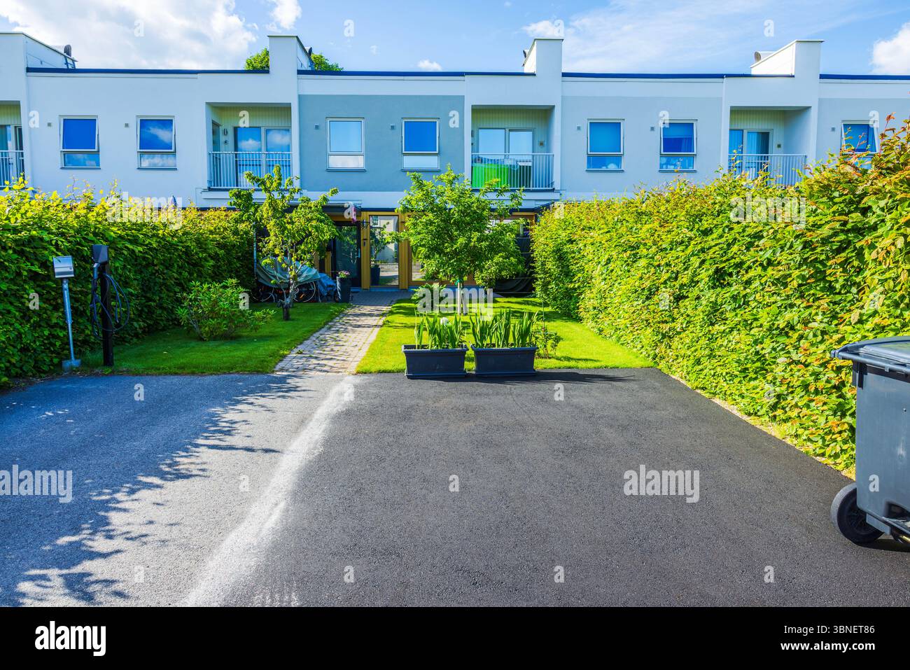 Front yard of modern townhouse with two parking spots, one for electric ...