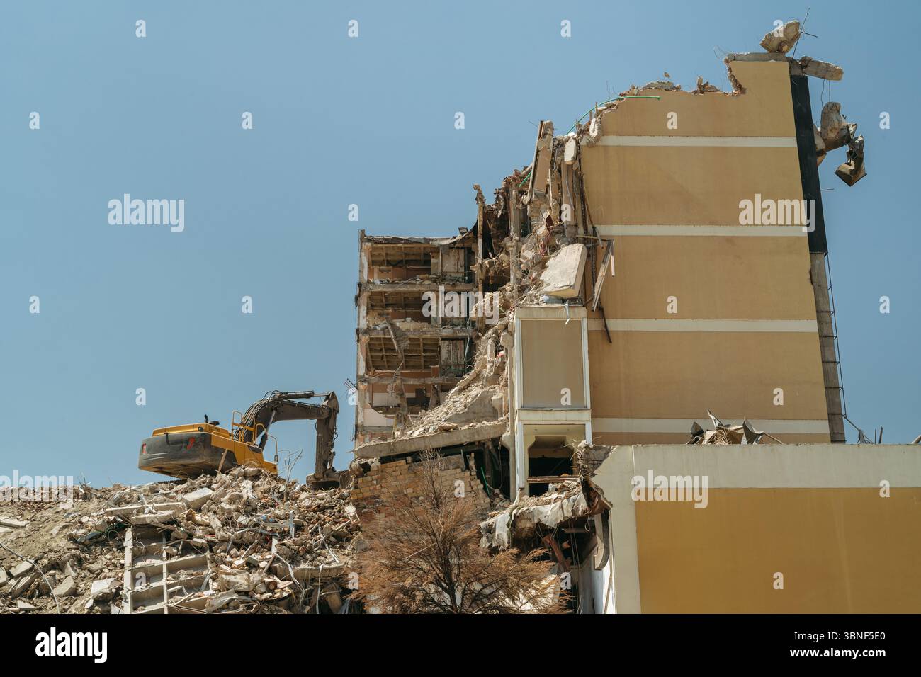 Demolition site with a collapsed building, exposed rebar, and a ...