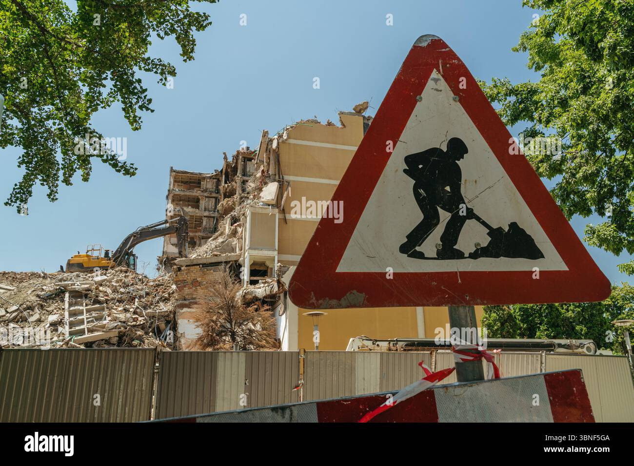 Construction warning sign in front of a collapsing building and active ...