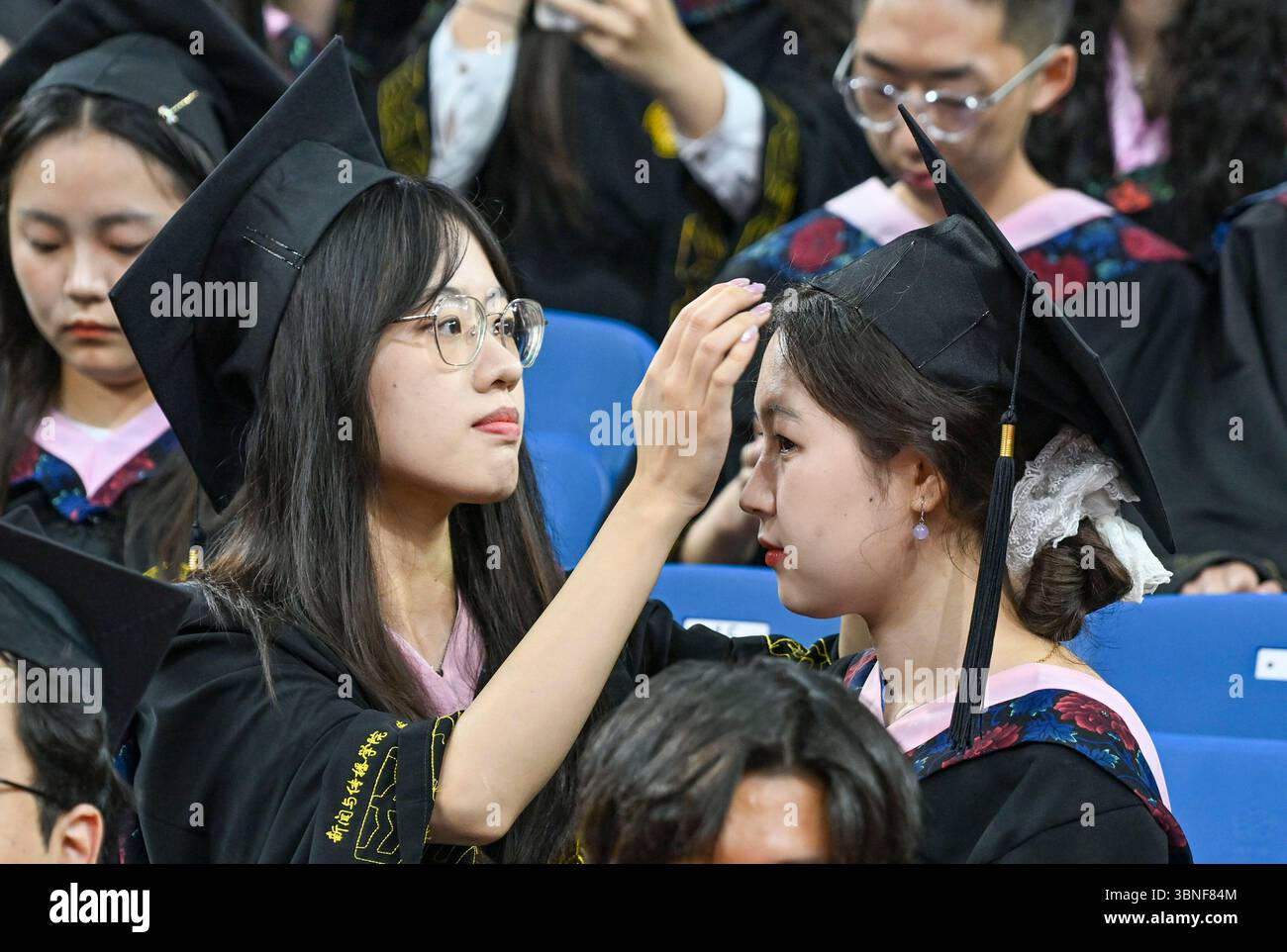 (250702) -- BEIJING, July 2, 2025 (Xinhua) -- A graduate adjusts the ...