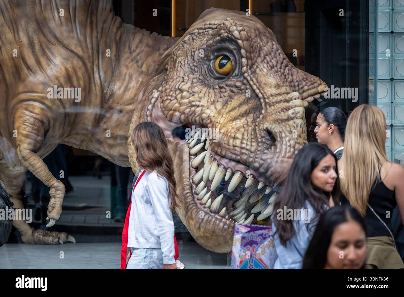 London, UK. 2 July 2025. People pass the T Rex dinosaur in the window ...