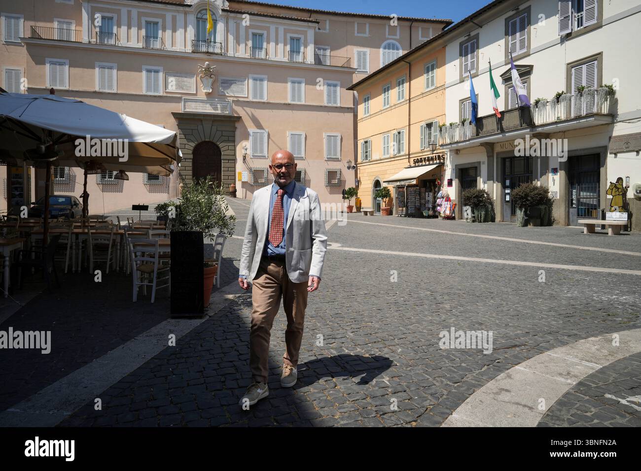 The mayor of Castel Gandolfo, Alberto De Angelis, walks past the Papal ...