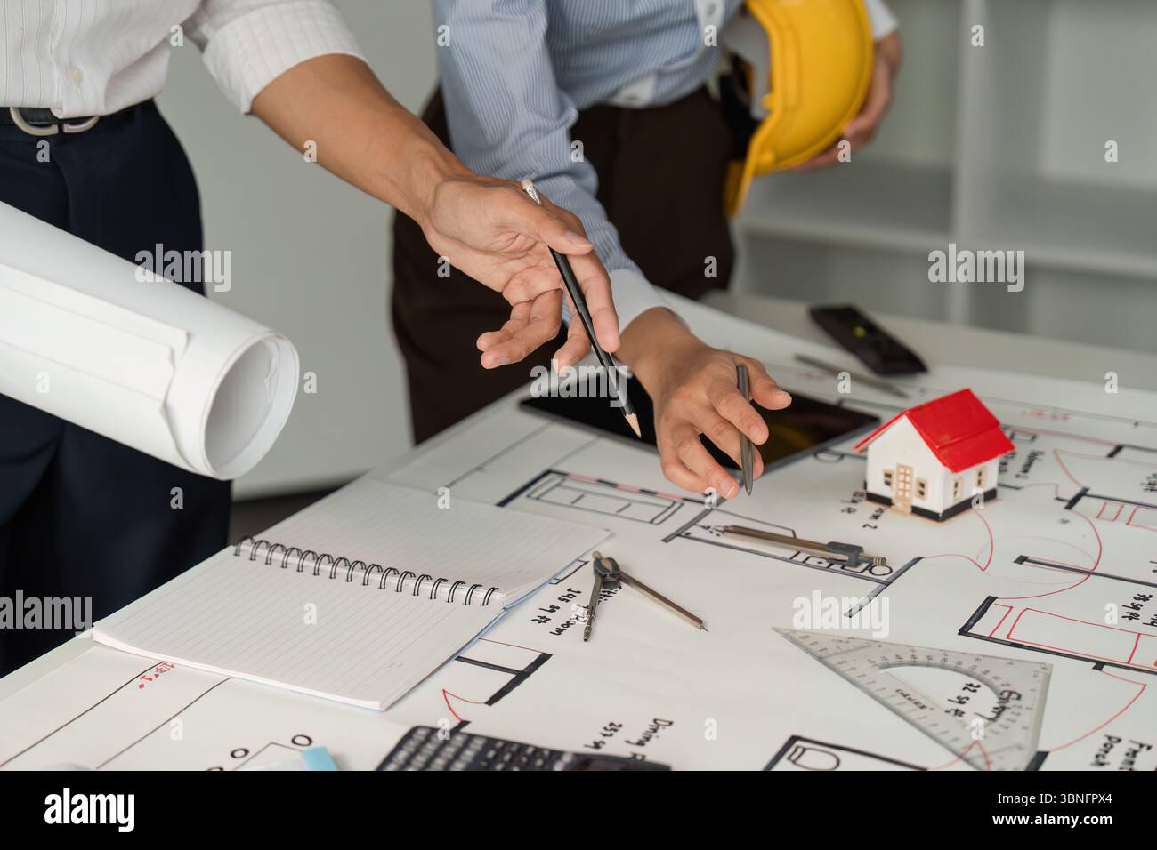 Design Development and Analysis. Professionals analyzing architectural blueprints and designs in ...