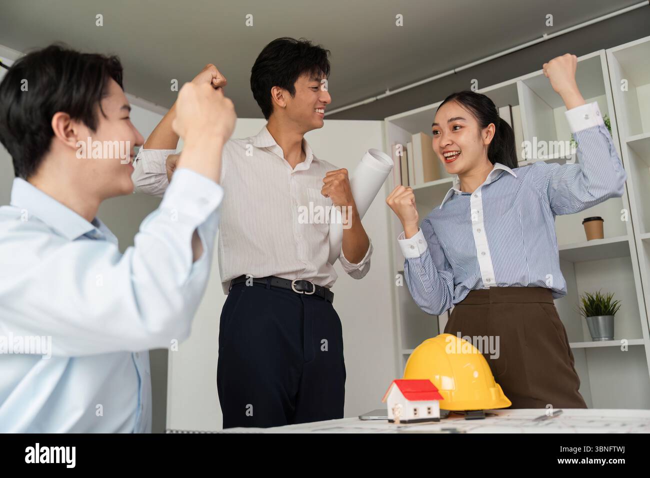 Collaboration and Achievement. A team of architects cheering after ...