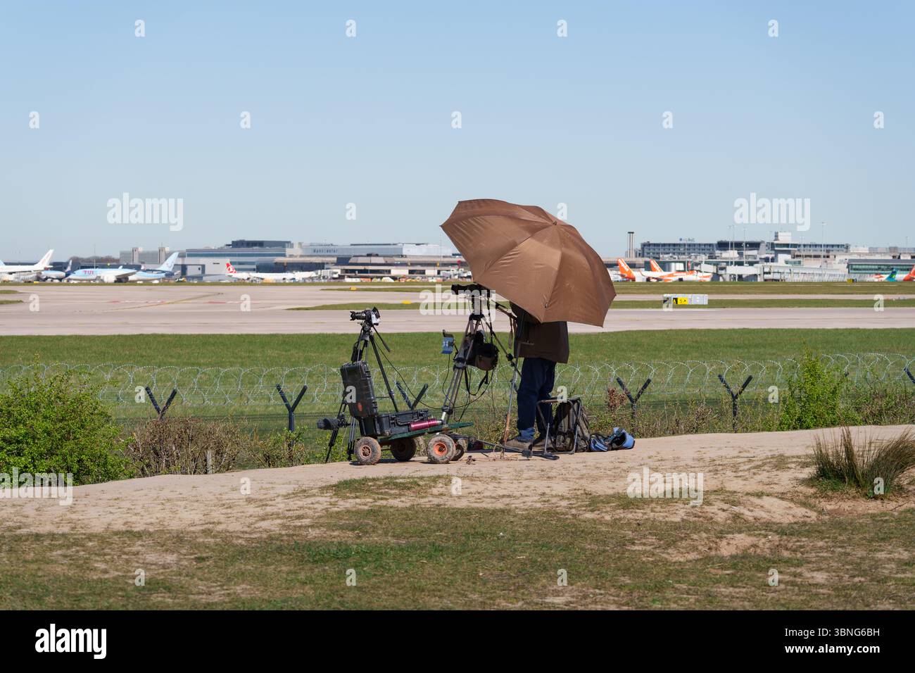 Plane spotter with his camera on a tripod set up at Manchester ...