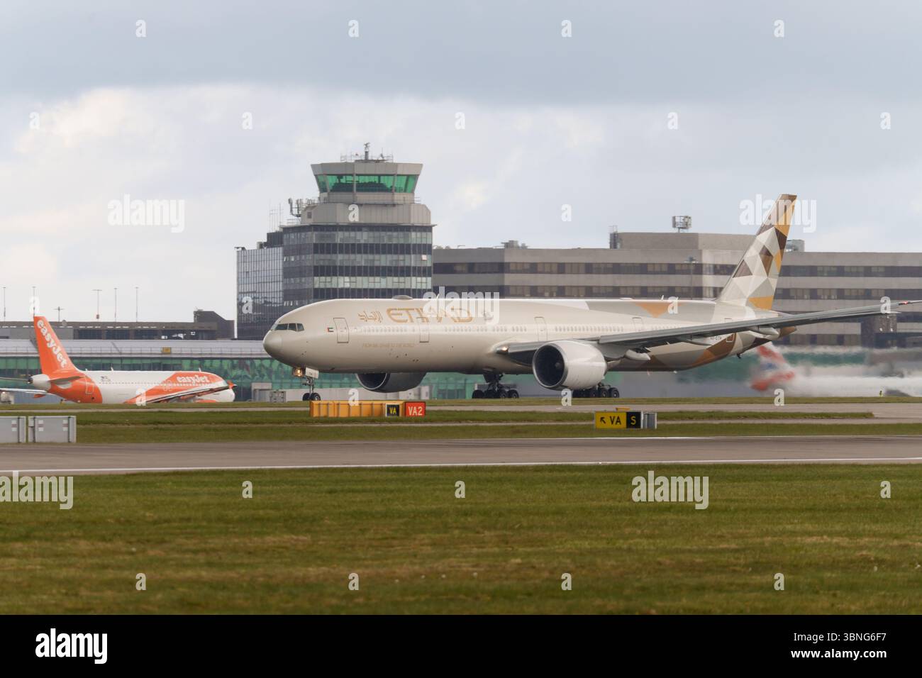Etihad airways Boeing 777 taking off under grey skies from Manchester ...