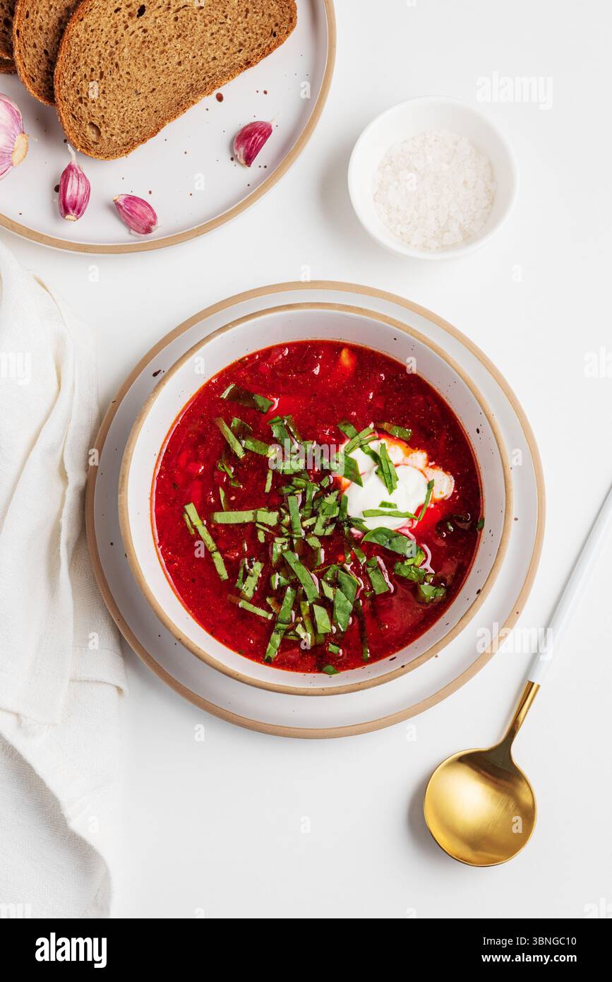 Traditional Ukrainian borscht with sour cream, garlic and rye bread on ...
