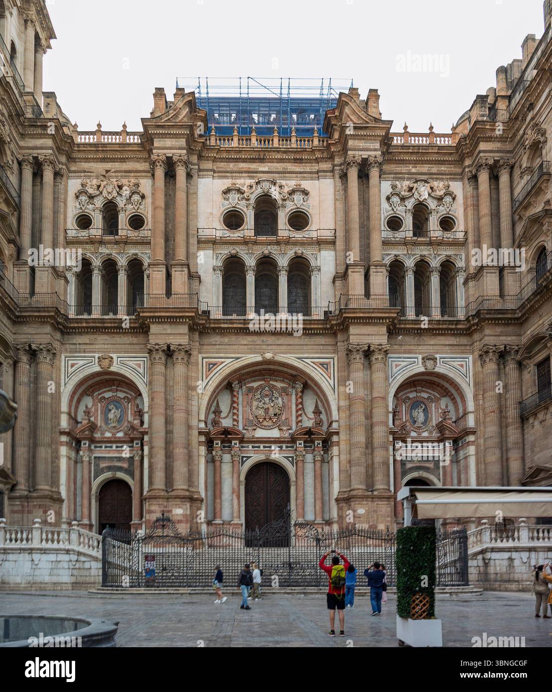 The photograph depicts the facade of the Cathedral of Malaga, a ...