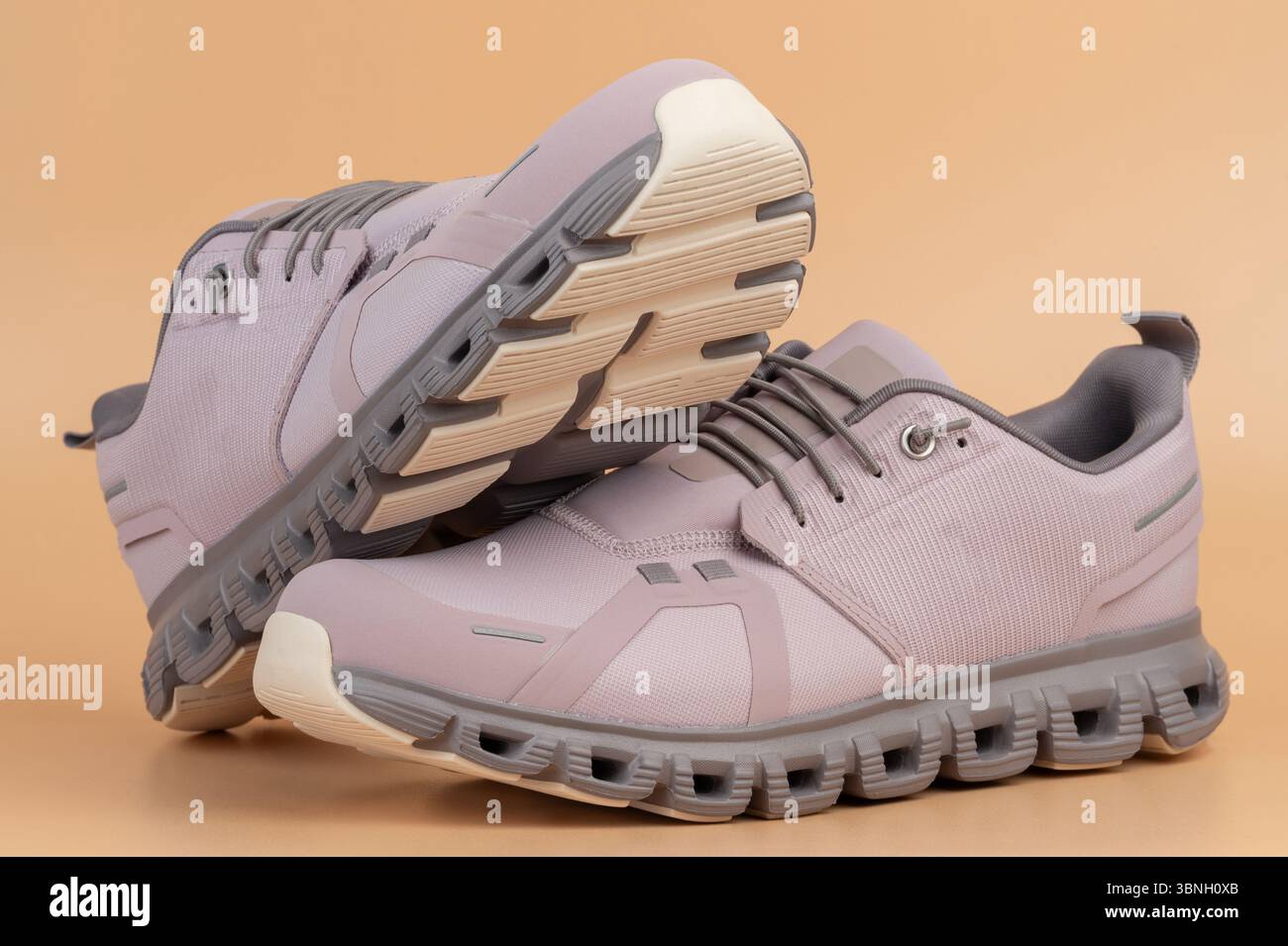 Modern gray athletic shoes positioned elegantly on neutral beige ...