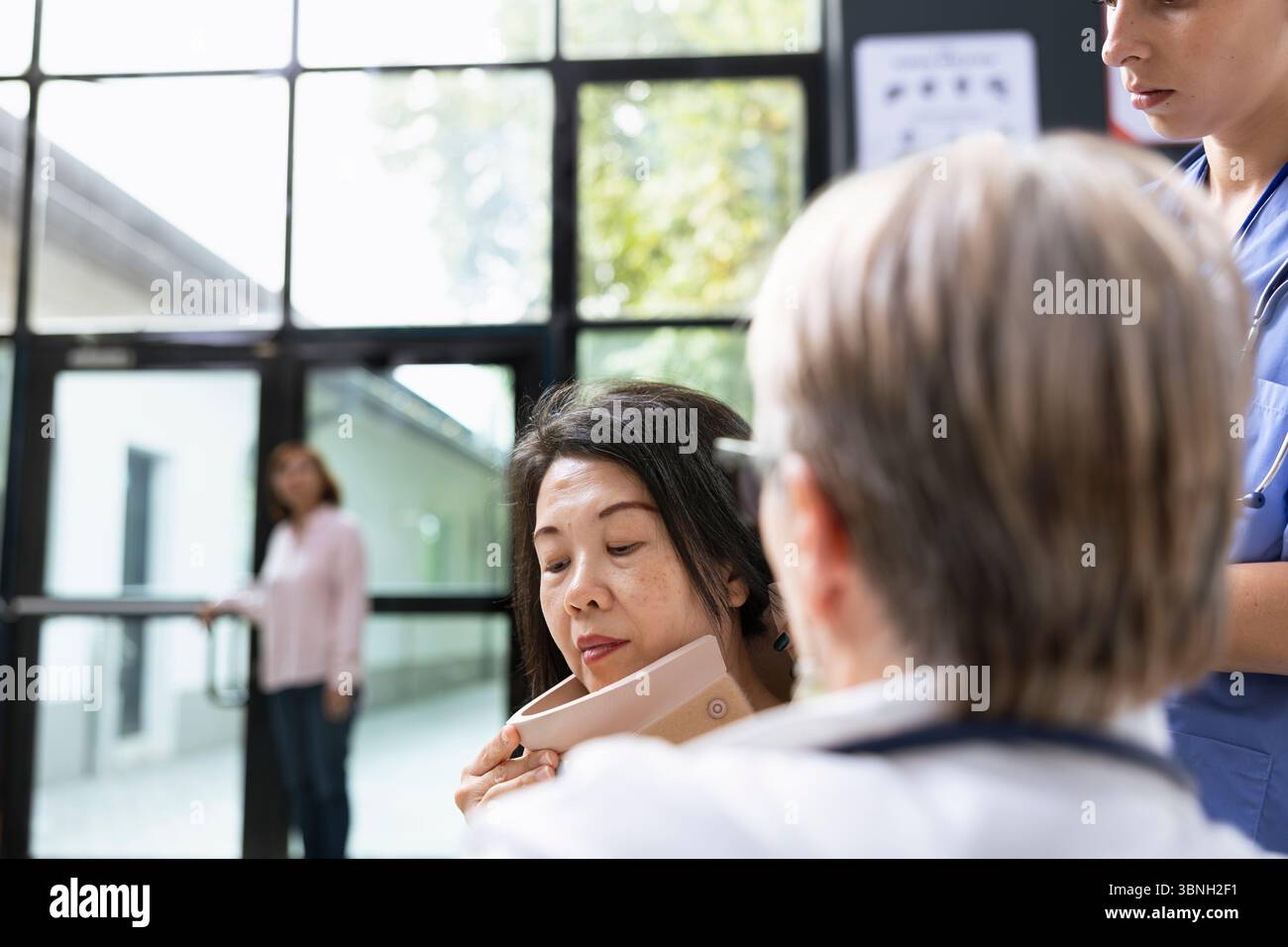 Medical professional assisting patient hurt by securing cervical ...