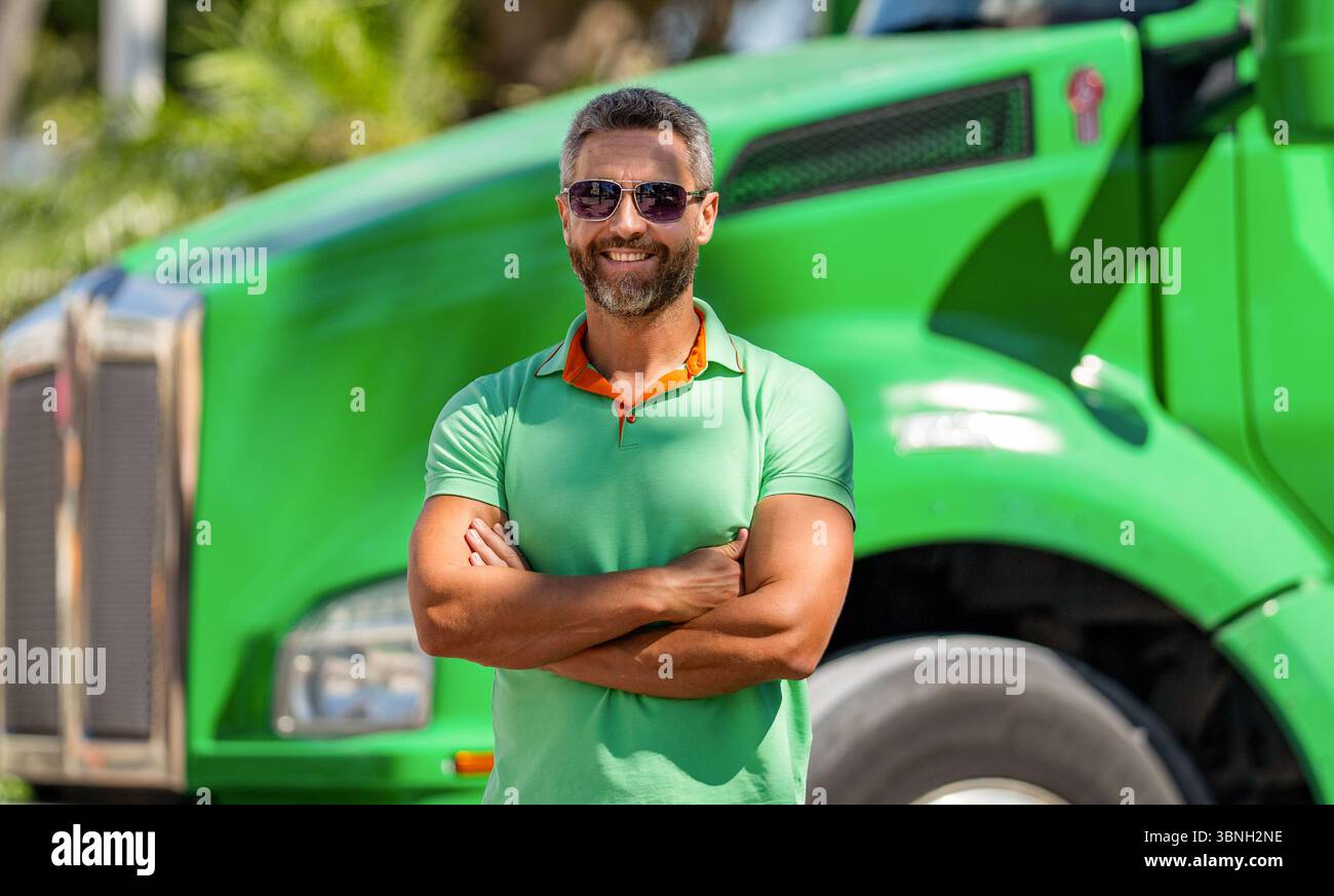 Handsome man driver in front of green truck. Trucking owner. Truck ...