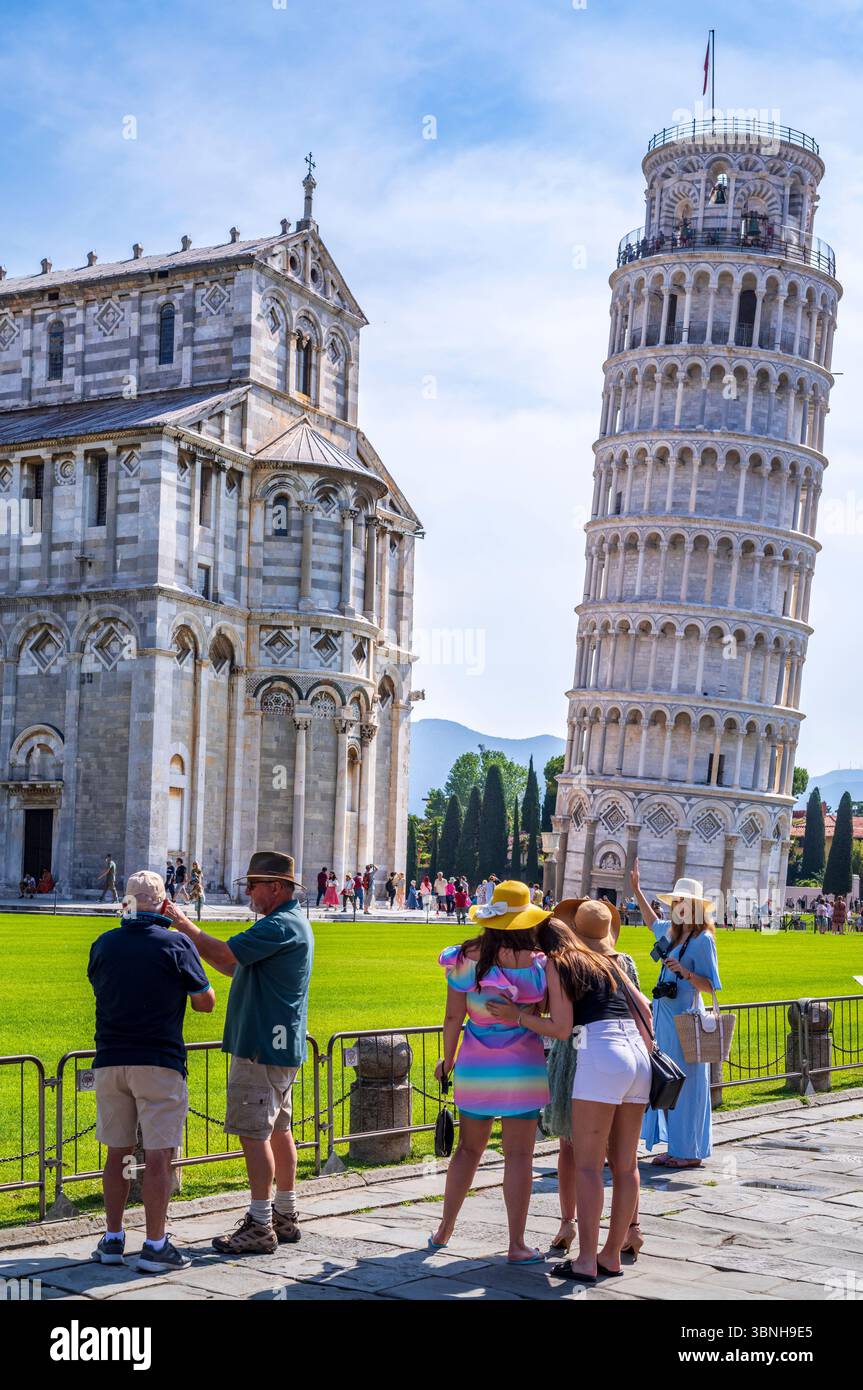 Tourists taking photographs of famous The Leaning Tower of Pisa and ...