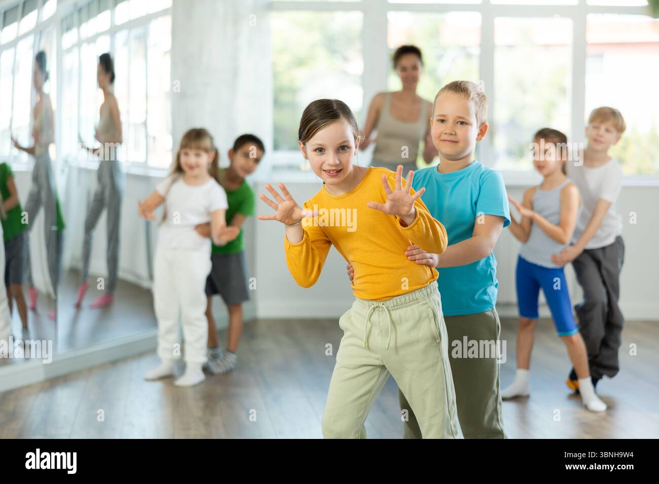 Group of children training movements of twist in dance studio with ...