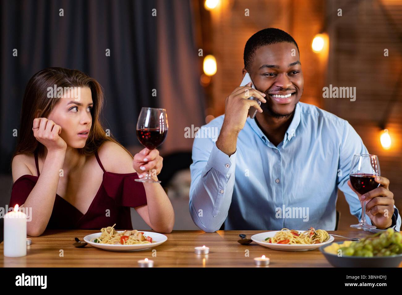 Boring Date. Black guy talking on cellphone in restaurant, ignoring his ...