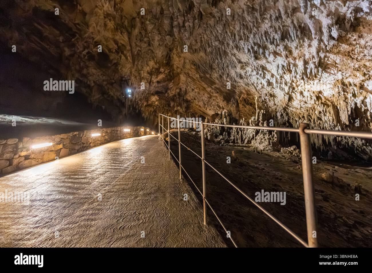 Illuminated walking path winding through frasassi caves, showcasing ...