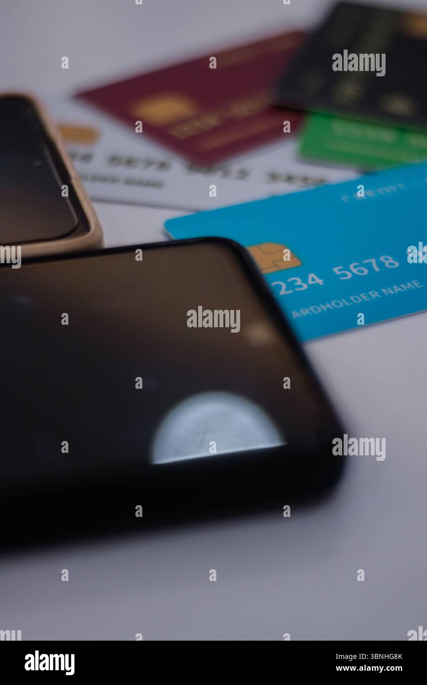 Modern phones placed over colorful credit cards, conveying the digital ...