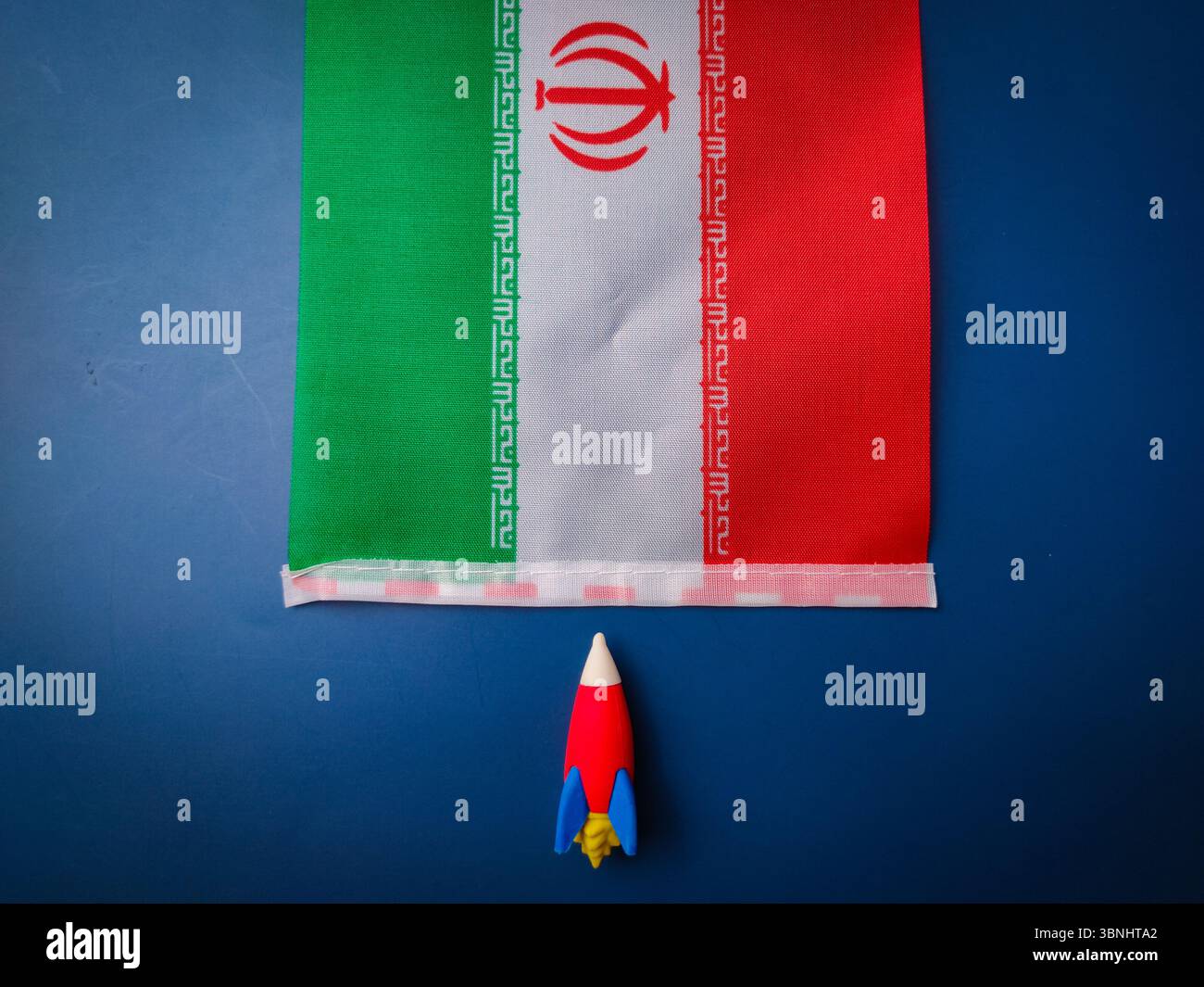 Toy rocket and iran flag on a blue background.Geopolitics concept Stock ...