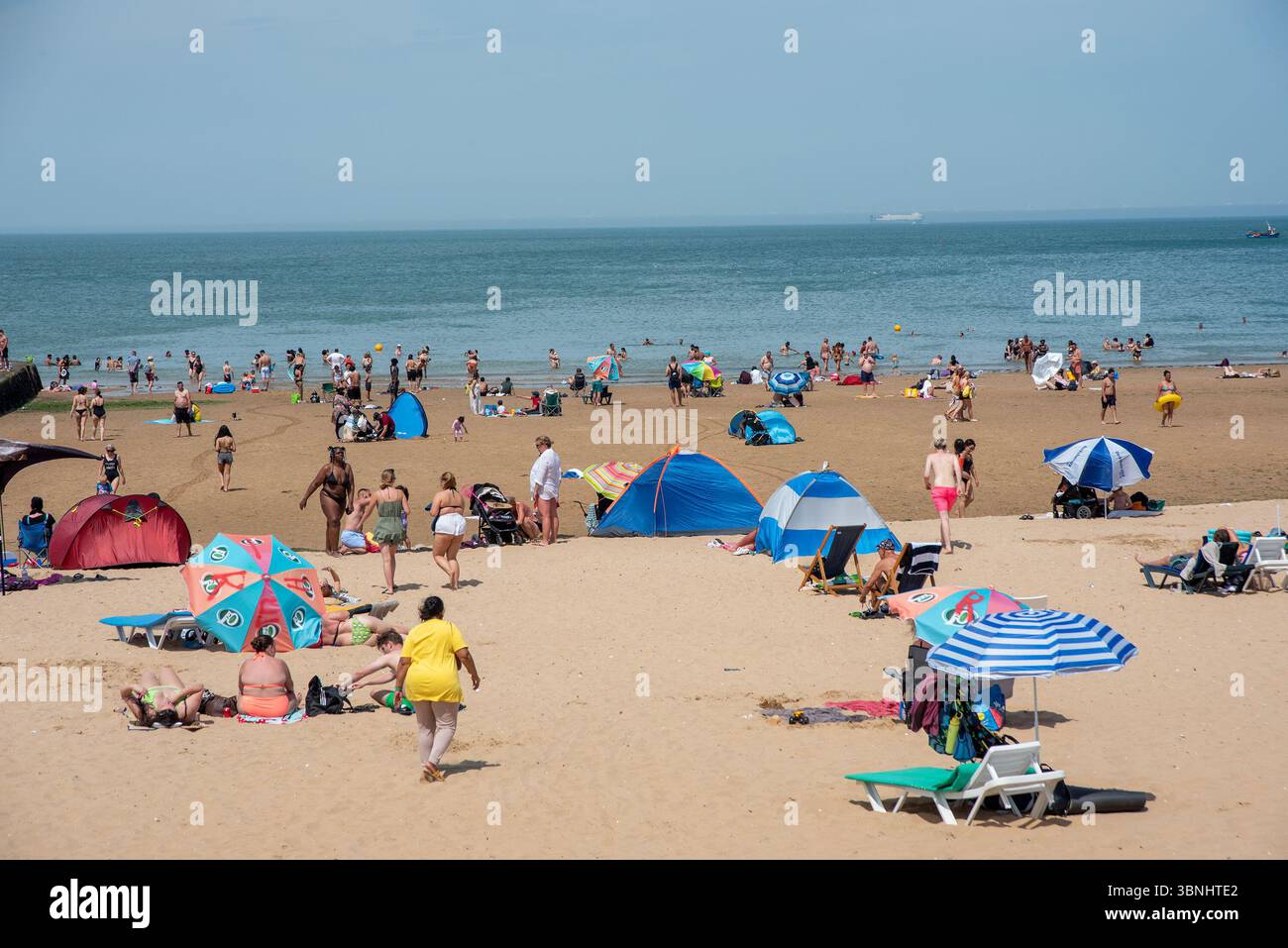 Beachgoers enjoy the sun on the sandy beach. Margate is a seaside town ...