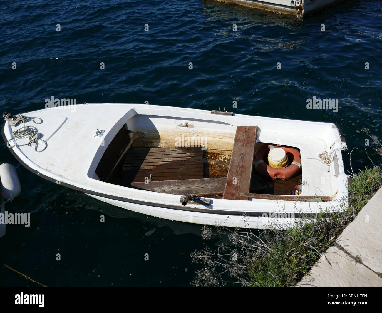 Sinking rowboat full of water and floating debris inside Stock Photo ...