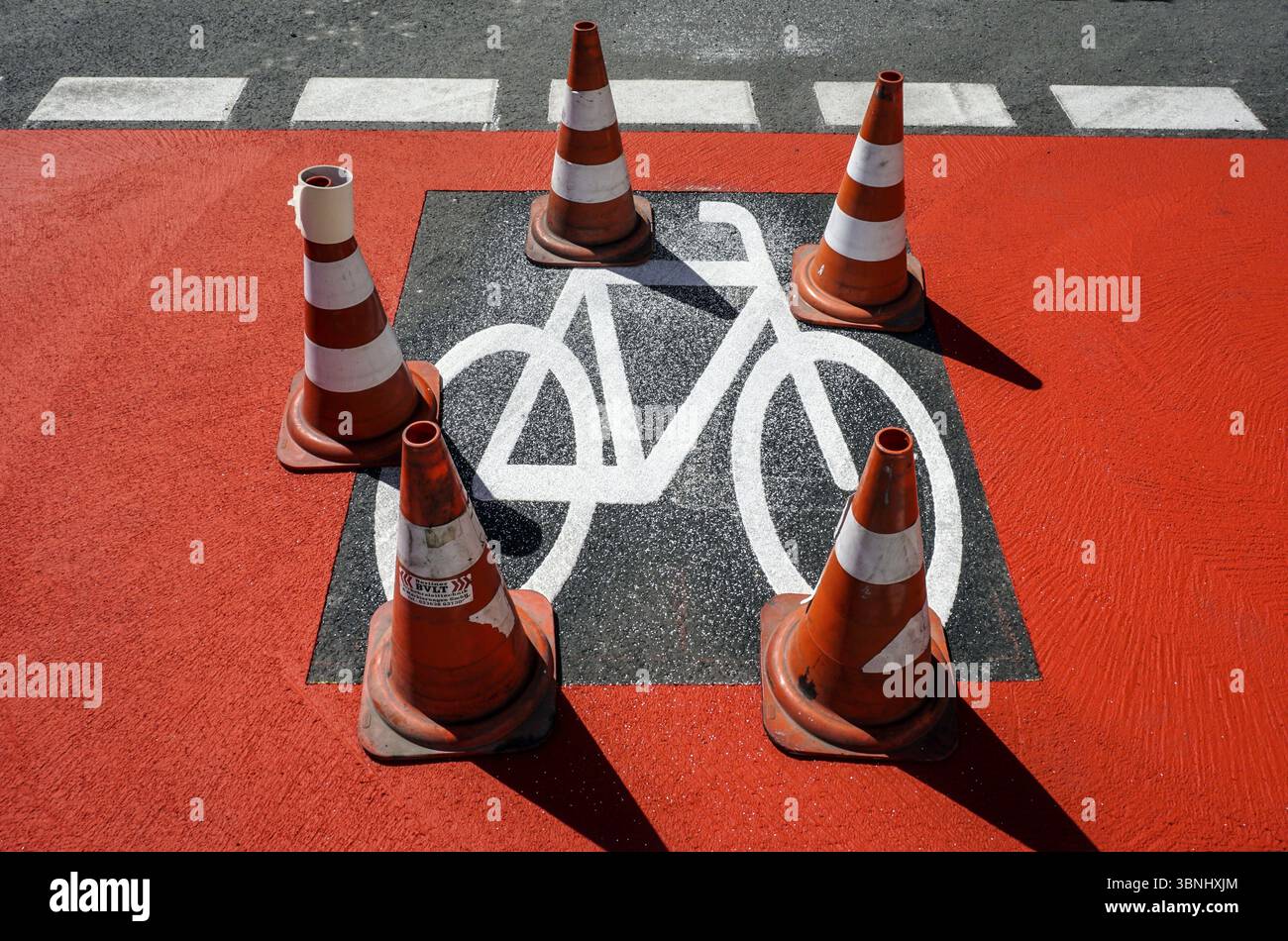 Warning cones standing on a cycle path sprayed with a stencil Symbol on ...
