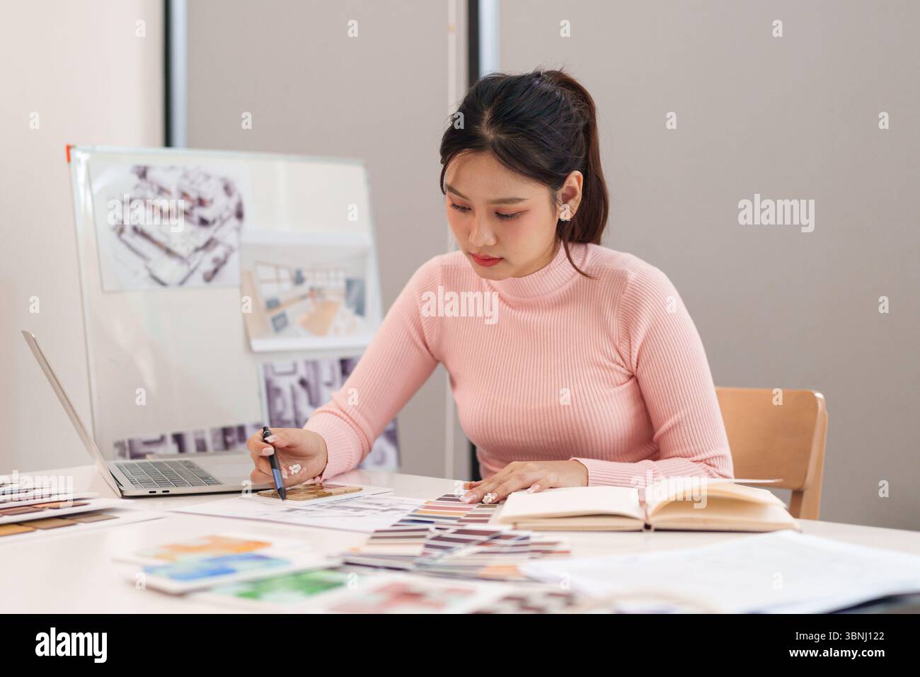 An adult Asian woman is working as a ui ux designer selecting colors ...