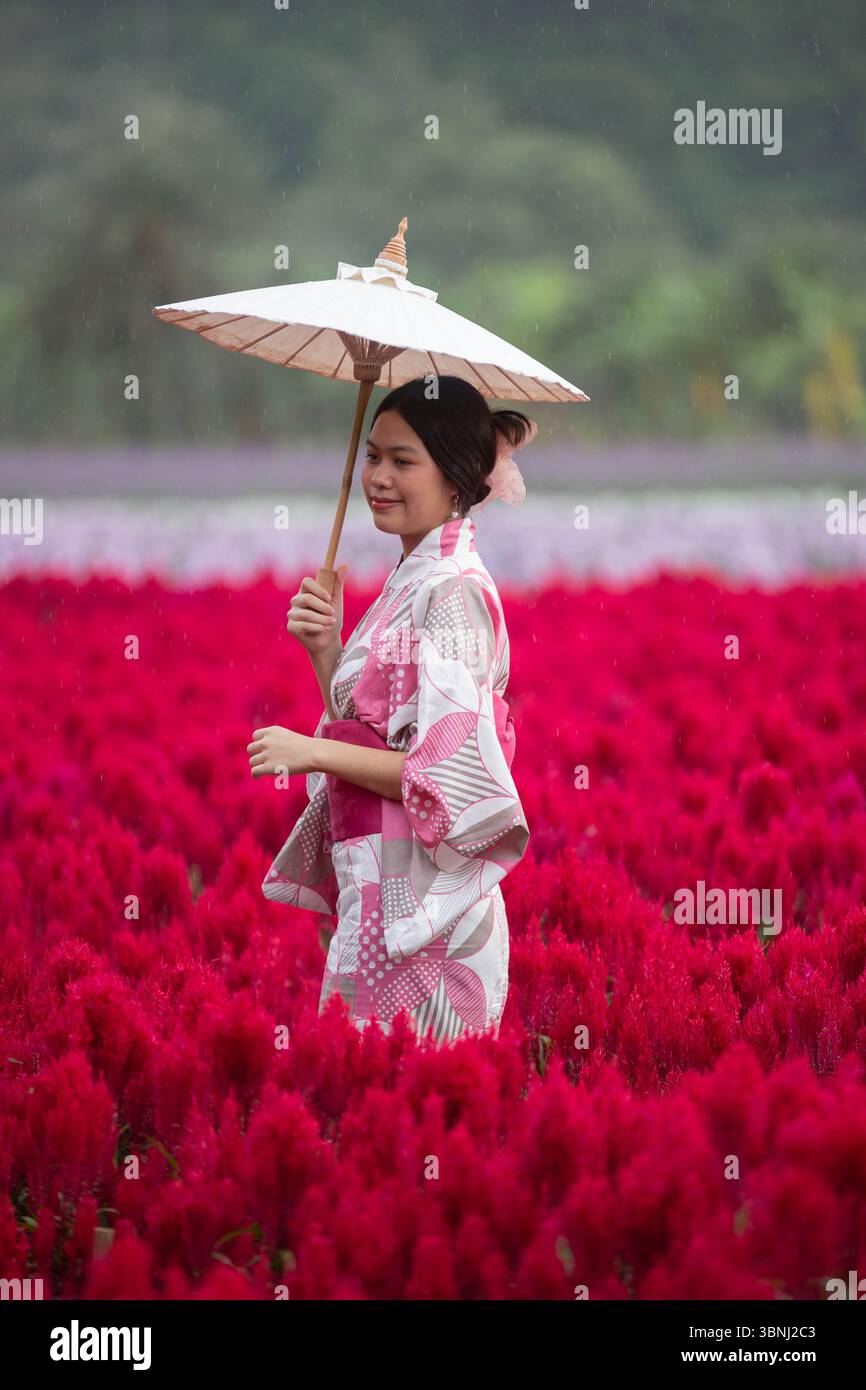 The beauty women of vast flower field in full bloom stretches. The ...