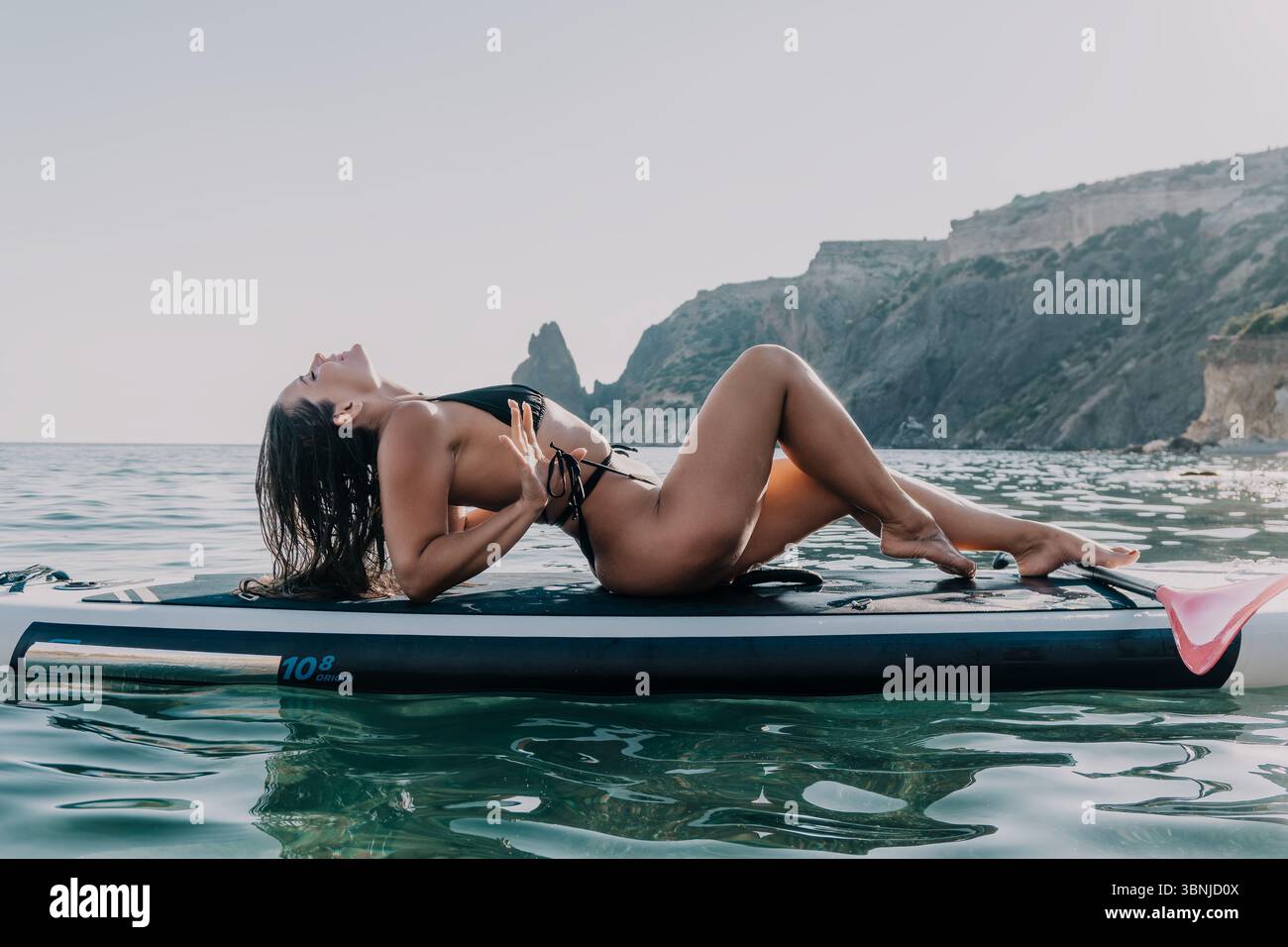 Woman Paddleboarding Ocean Coastline Relaxing Stock Photo - Alamy