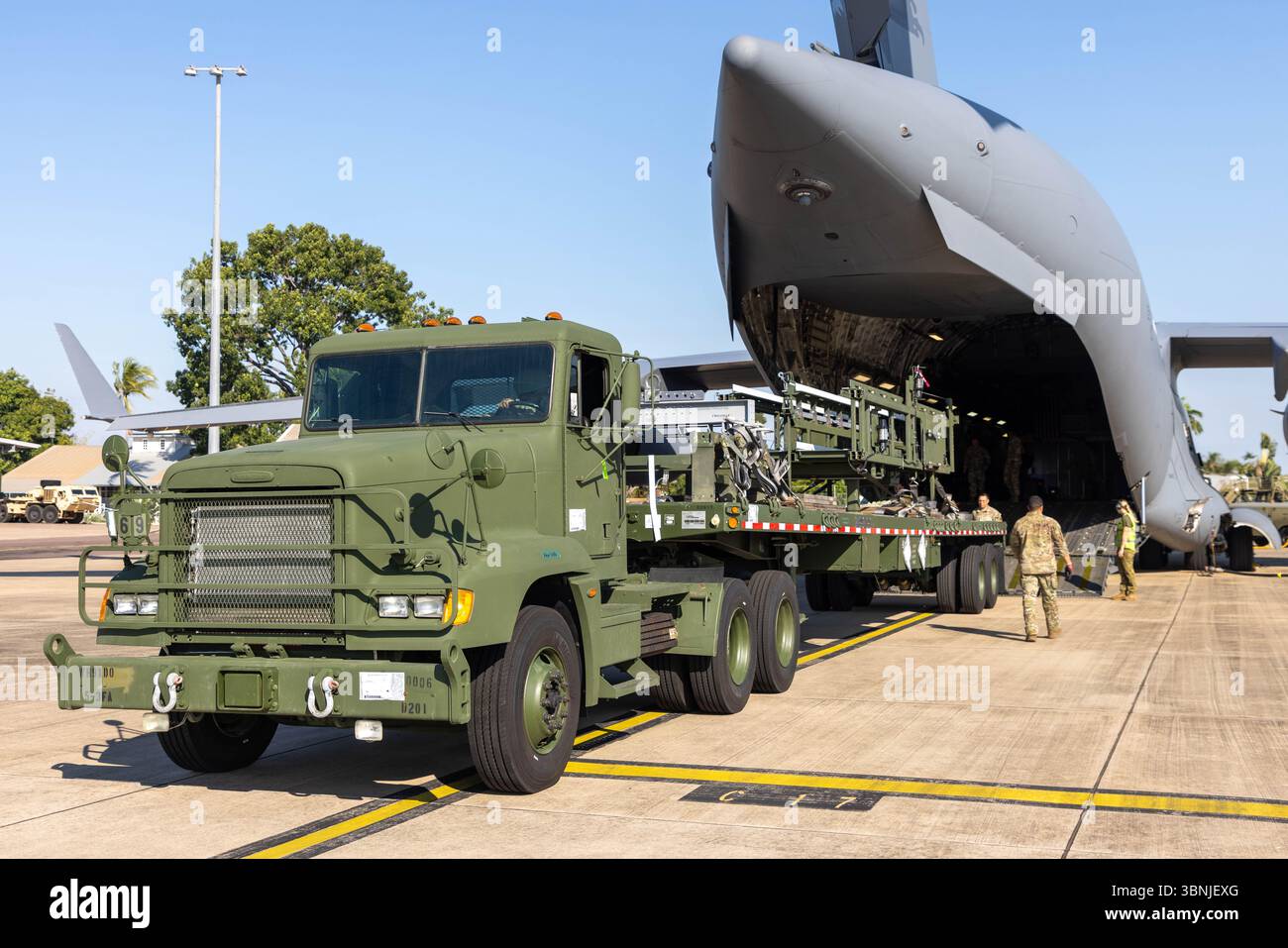 Military flatbed trailer offloads from a U.S. Air Force C-17 aircraft ...