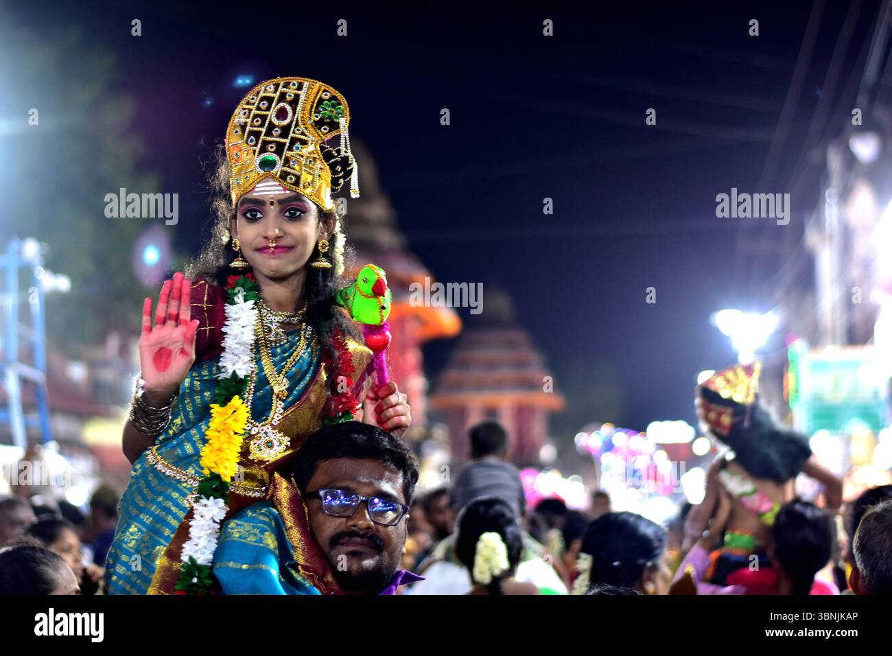 A young girl dressed as a Hindu goddess is carried by a devotee during ...