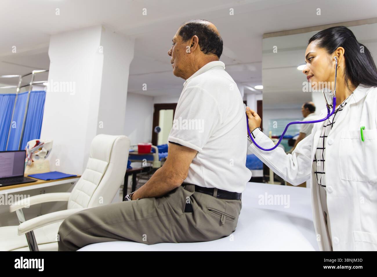 A doctor is using a stethoscope to examine a patient in a Latin ...