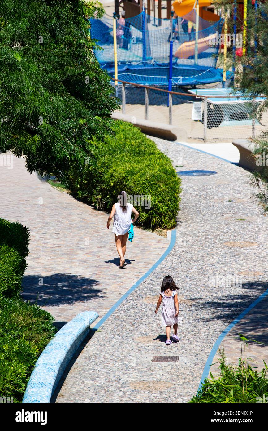 Woman walking along resort alley hi-res stock photography and images ...