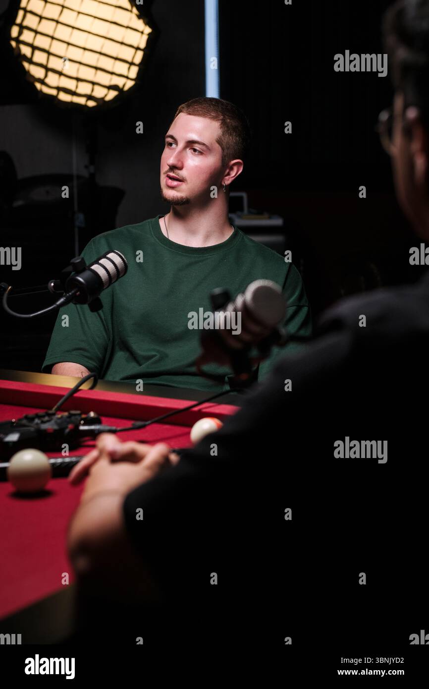 A young podcast host is engaged in a lively discussion during a live ...