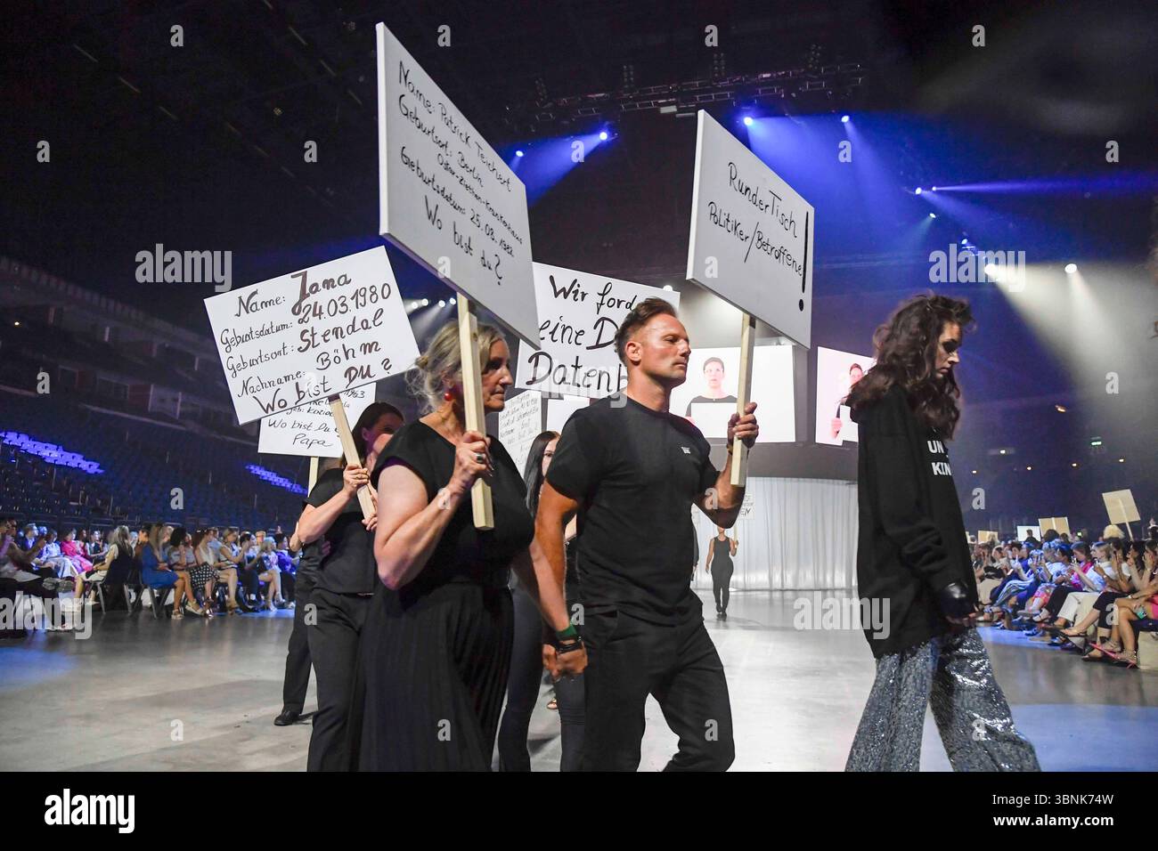 Models auf dem Catwalk mit Protest Schildern auf der Fashion Show von ...