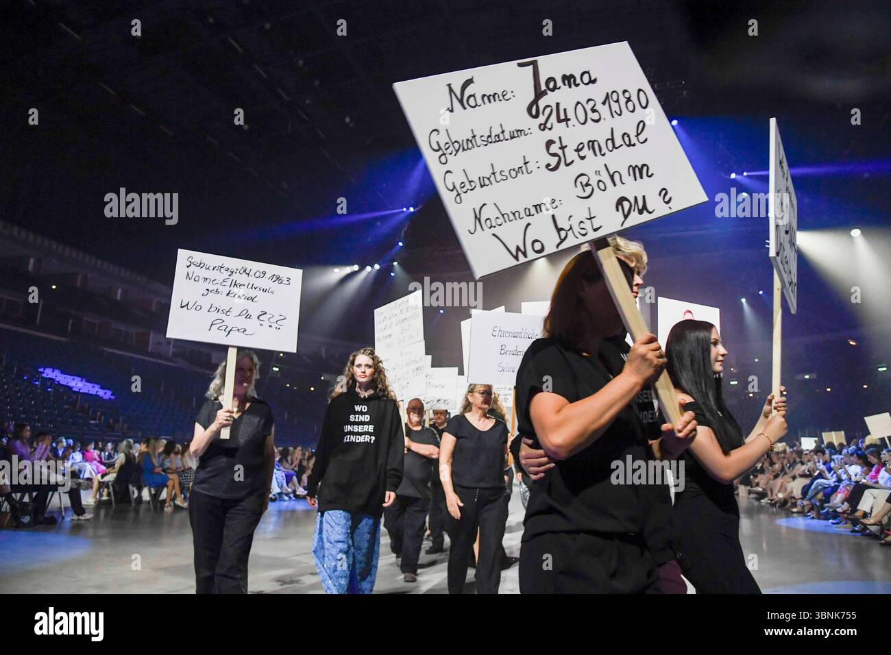Models auf dem Catwalk mit Protest Schildern auf der Fashion Show von ...
