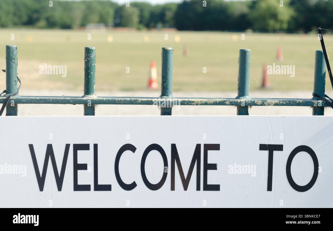 sign on a green railing fence in black letters on a white background ...