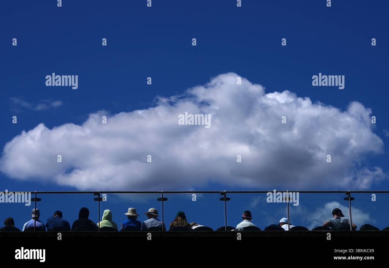Spectators watch tennis on court three during the Wimbledon Tennis ...