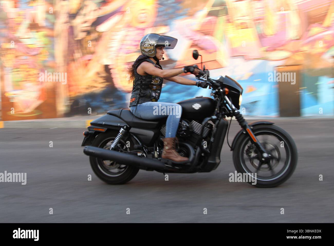 Empowering image of a female motorcyclist confidently riding a Harley ...