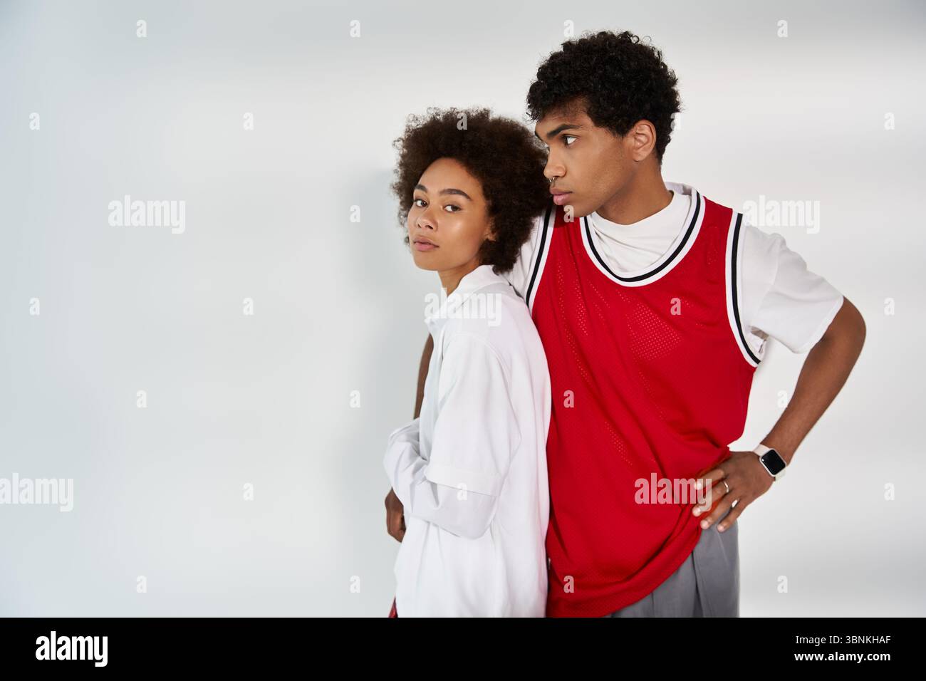 A loving couple stands close, showing off their unique style and deep ...