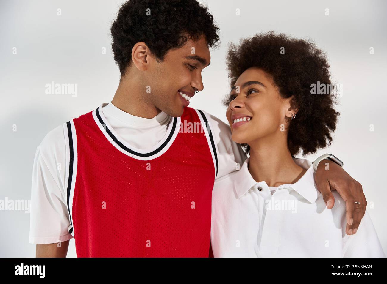 Stylish couple enjoys a tender moment, gazing lovingly at each other in ...