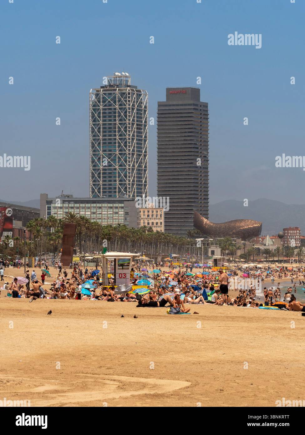 Sunbathers pack Barceloneta Beach in summer, with the iconic Hotel Arts ...