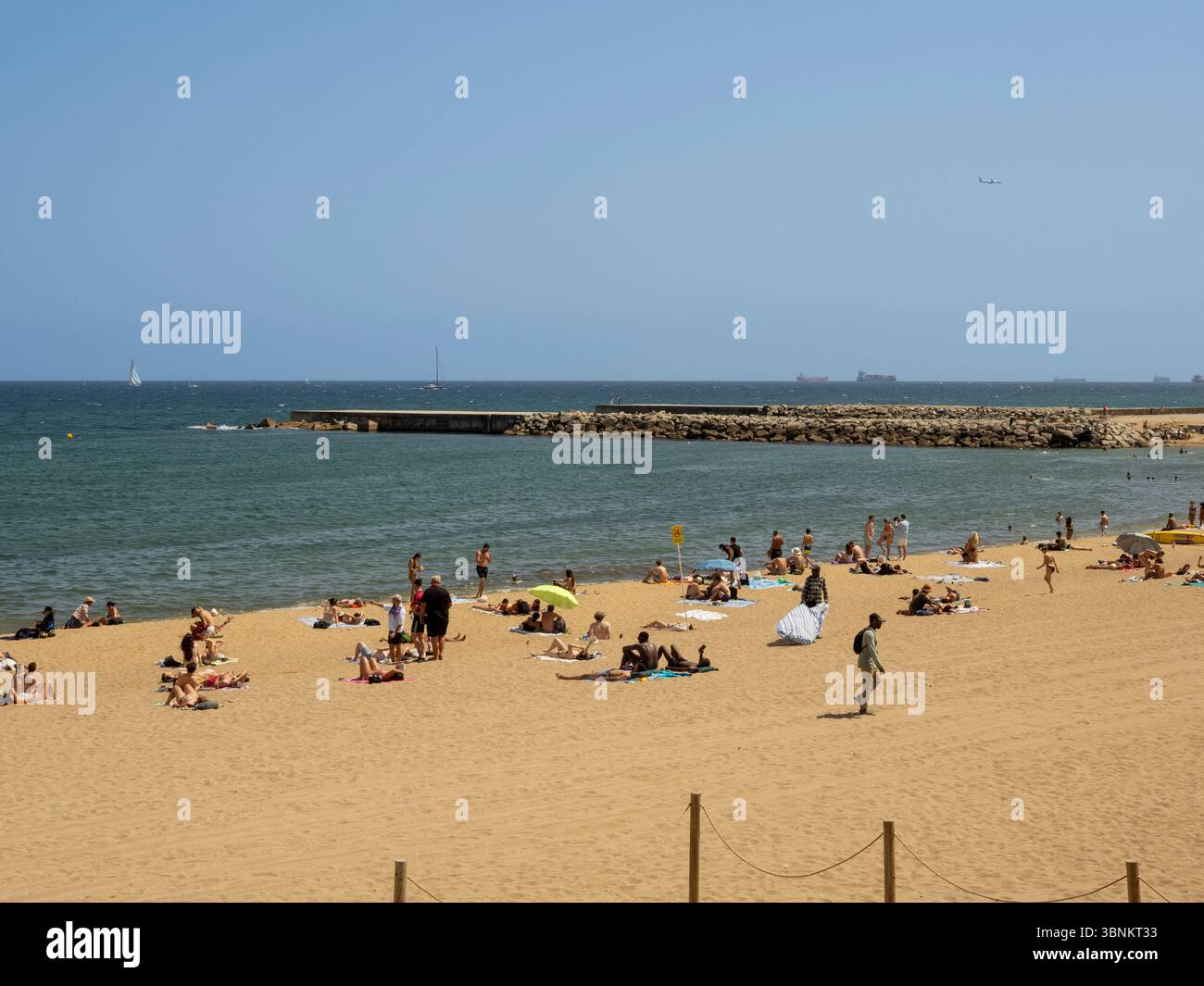 Beachgoers relax on the golden sand of Somorrostro Beach in Barcelona ...