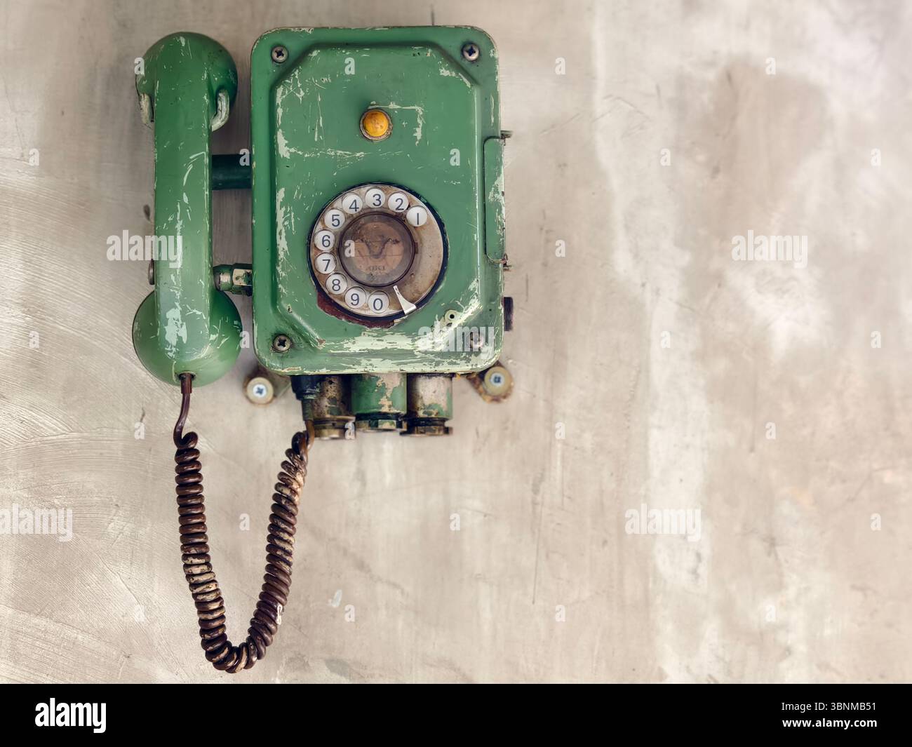 An old green vintage rotary dial telephone on a concrete wall Stock ...