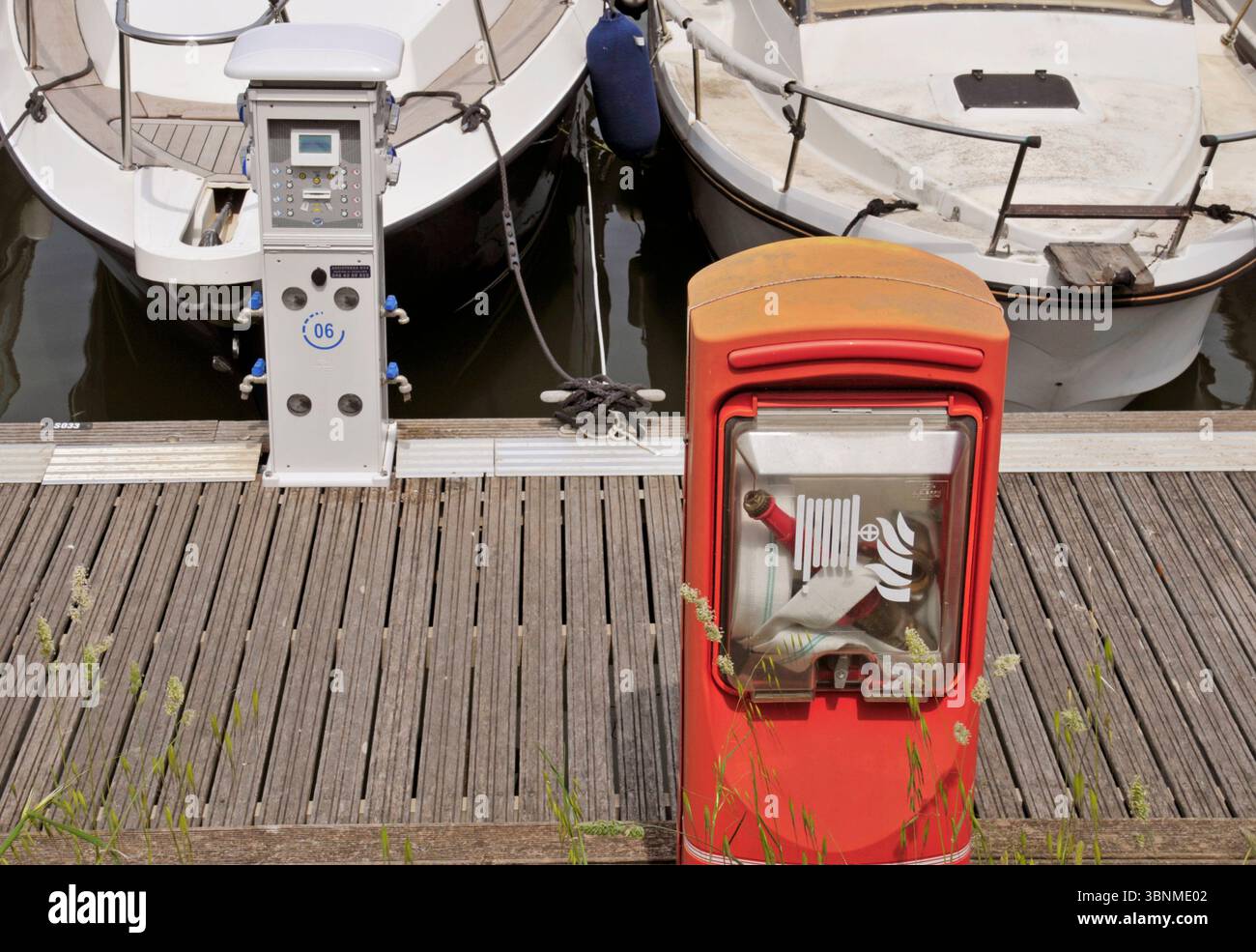 Boating marina fire hose and electricity control point alongside boats ...